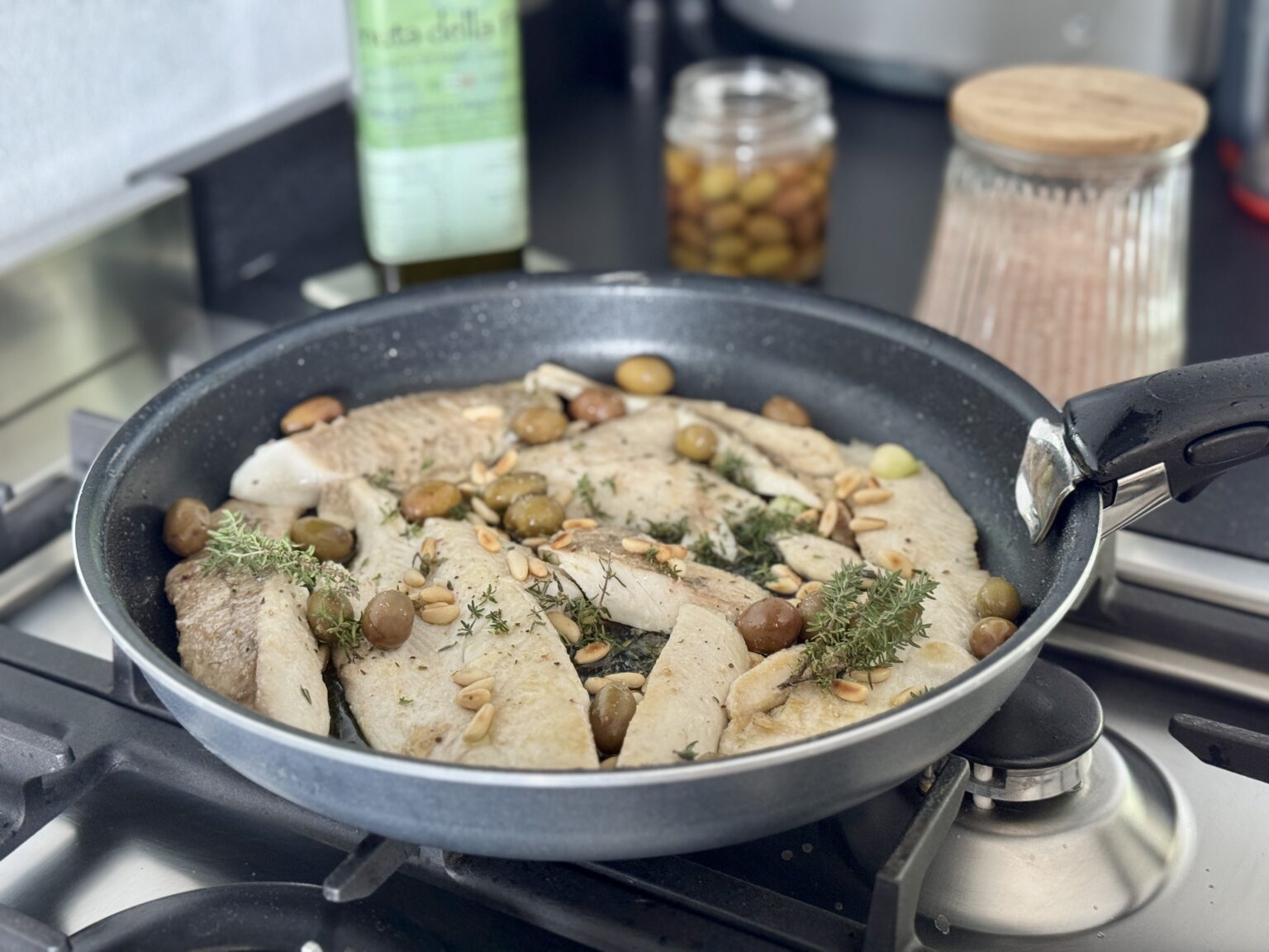 Filetti di pesce alla ligure in padella con olive, pinoli e timo